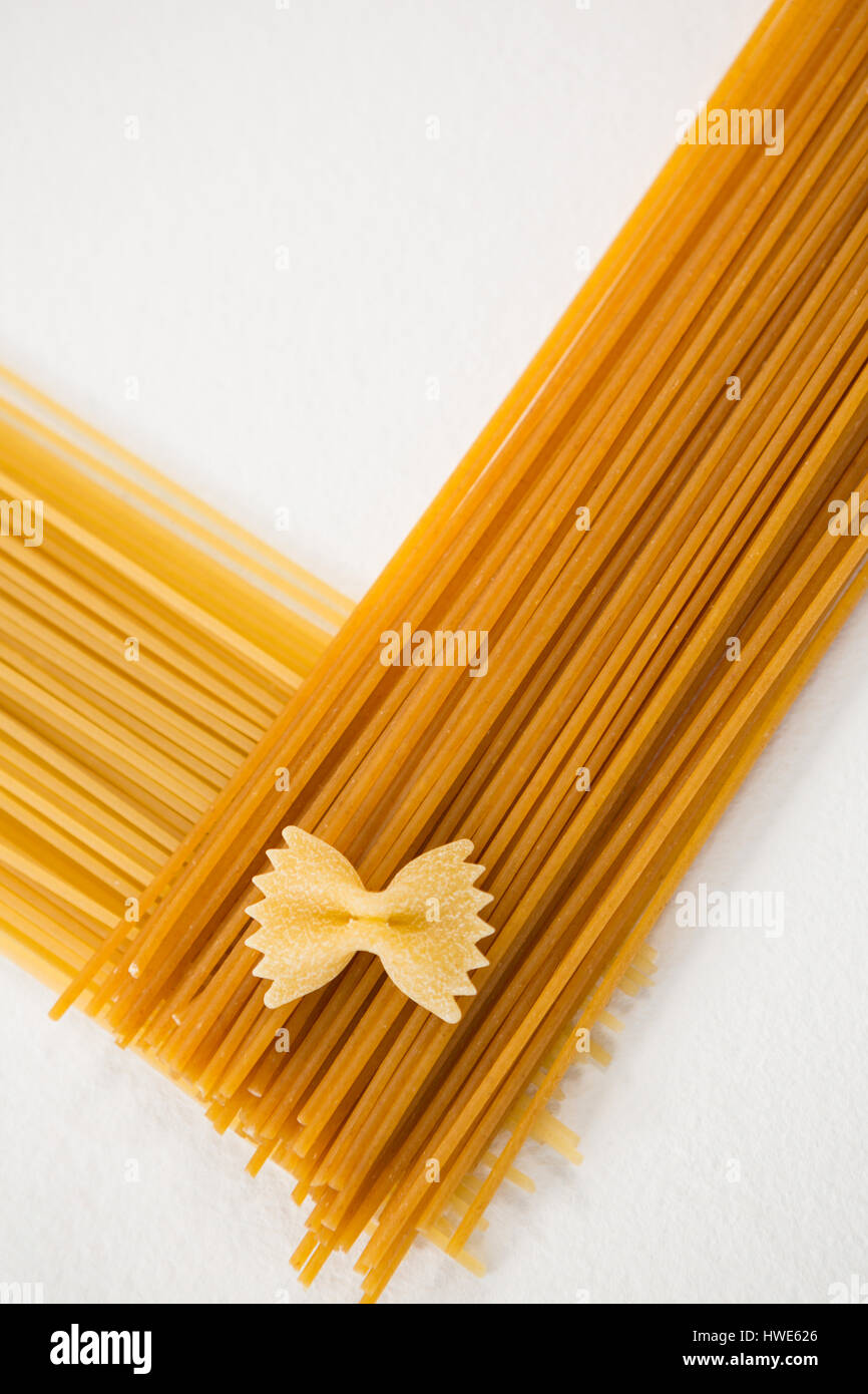 Close-up of farfalle and spaghetti pasta arranged on white background ...