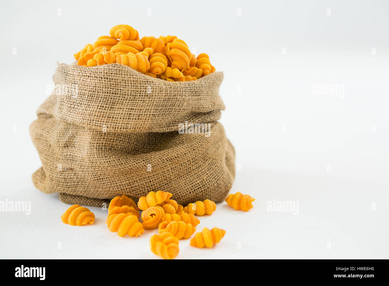 Sack full of yellow pasta on white background Stock Photo - Alamy
