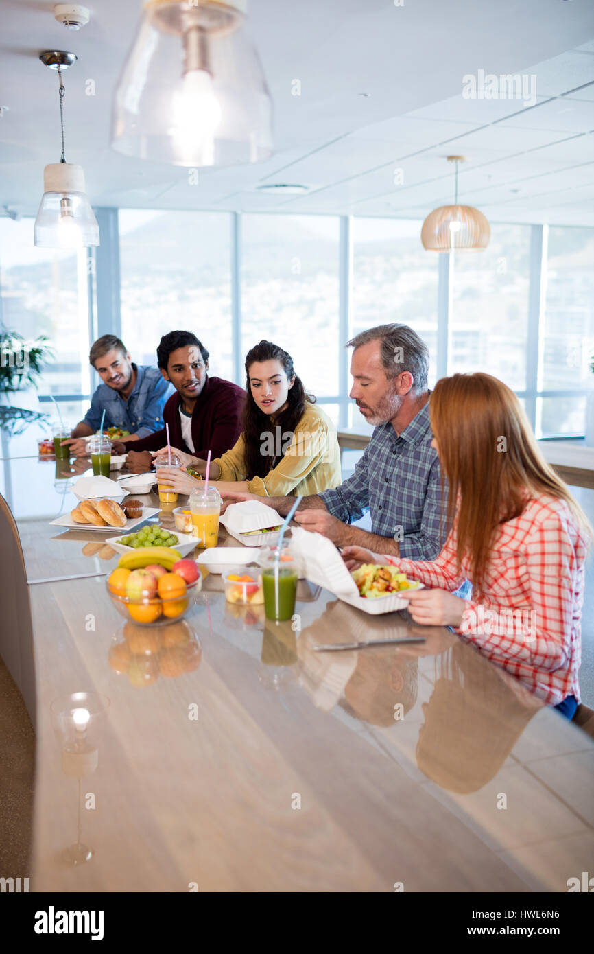 Creative business team having meal in office Stock Photo - Alamy