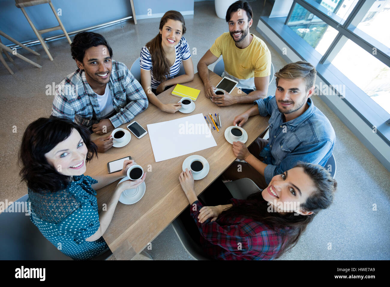Portrait of creative business team having meeting over coffee in ...