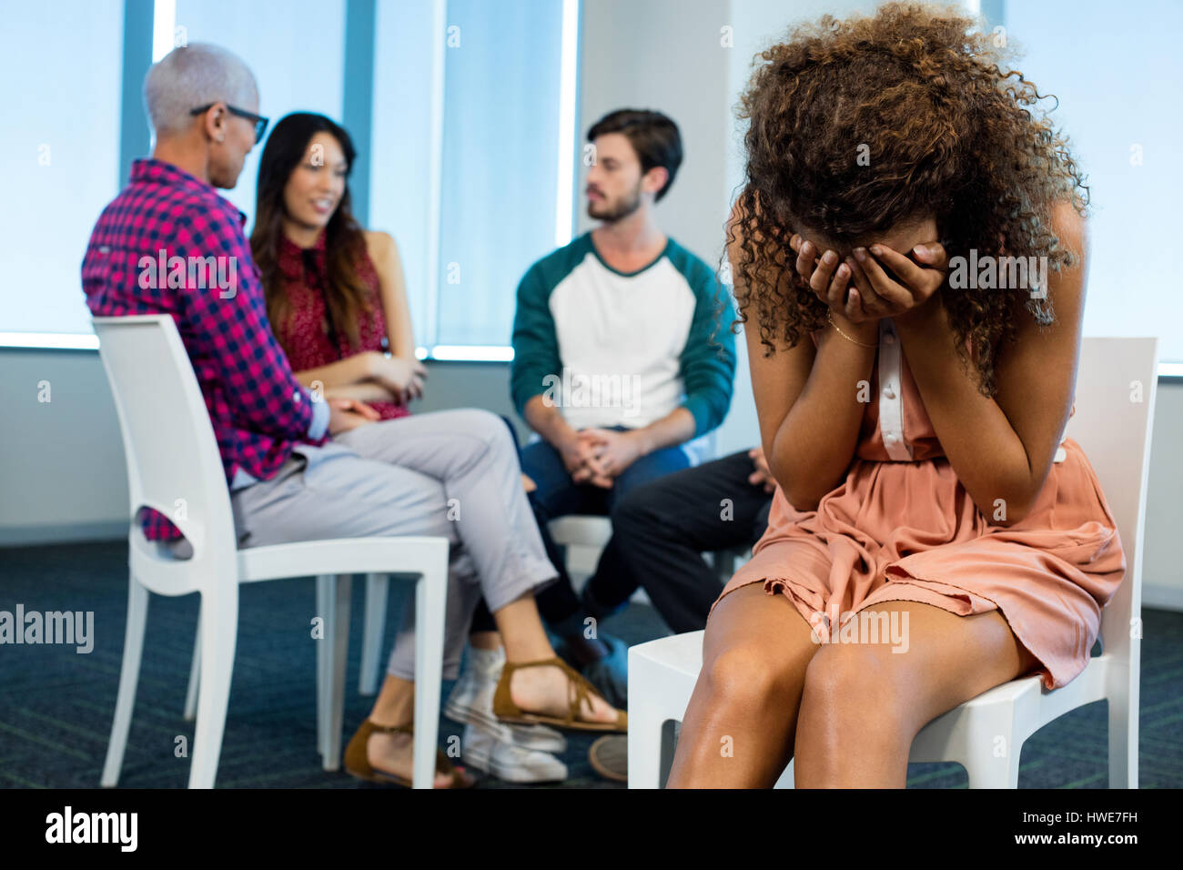Woman crying while creative business team in background at office Stock ...