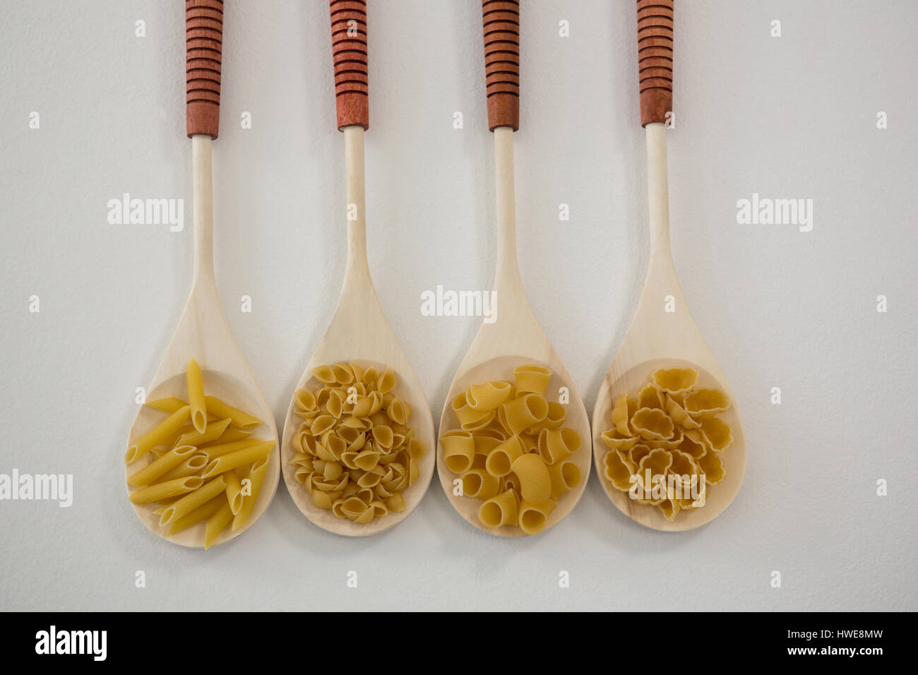 Spoons filled with varieties of pasta on white background Stock Photo ...