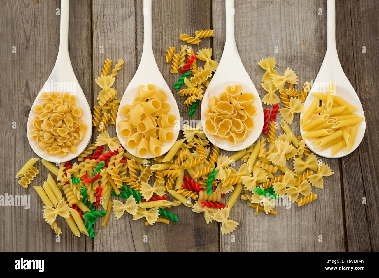 Spoons filled with varieties of pasta on wood surface Stock Photo - Alamy