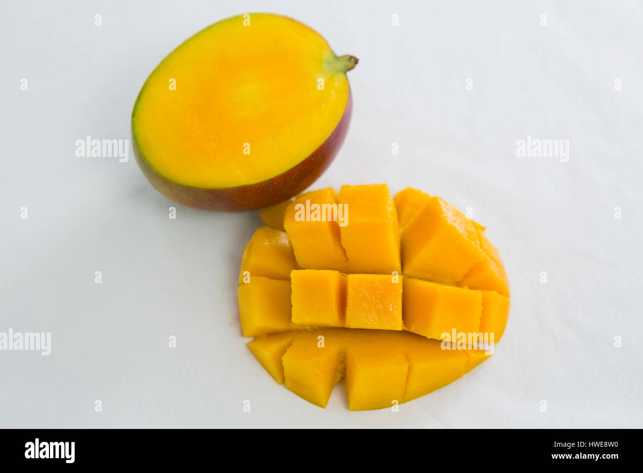 Close-up of halved and chopped mango on white background Stock Photo ...