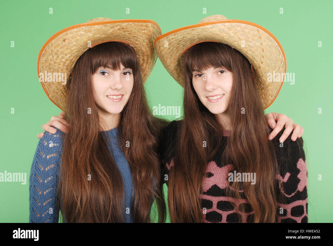 Beautiful two twins sisters on green background Stock Photo - Alamy