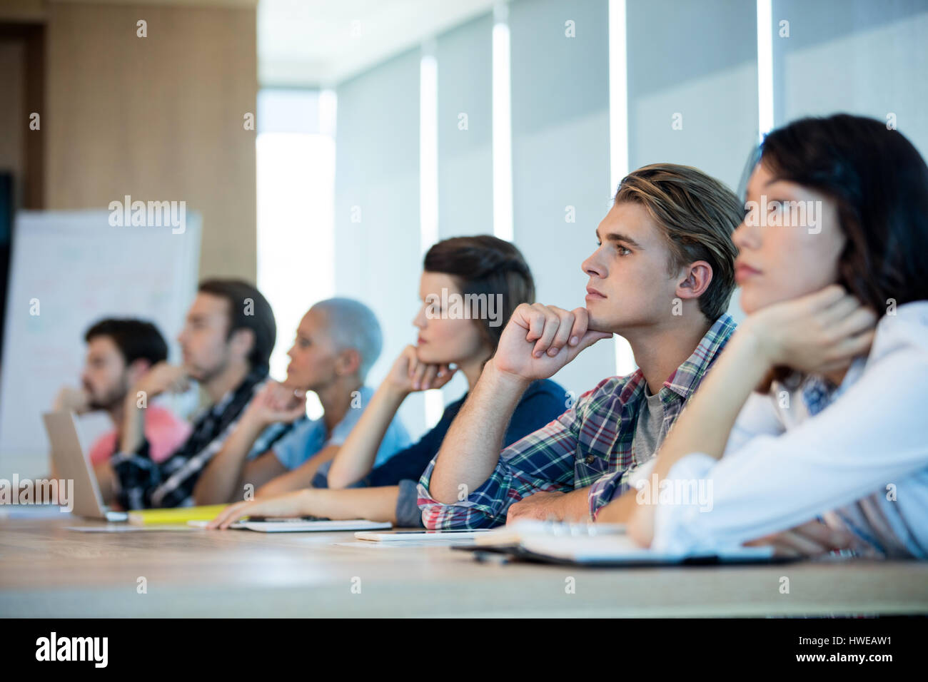 Creative business team listening at meeting in conference room at ...