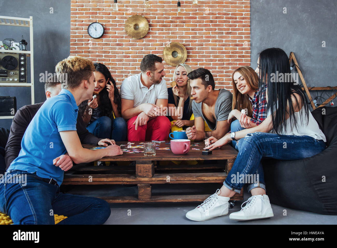 Group of creative friends sitting at wooden table. People having fun ...