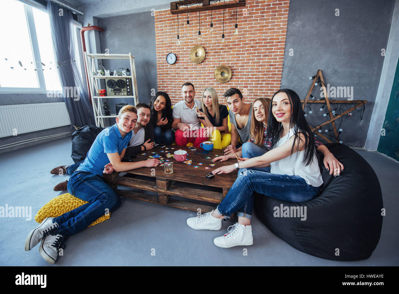 Group of creative friends sitting at wooden table. People having fun ...