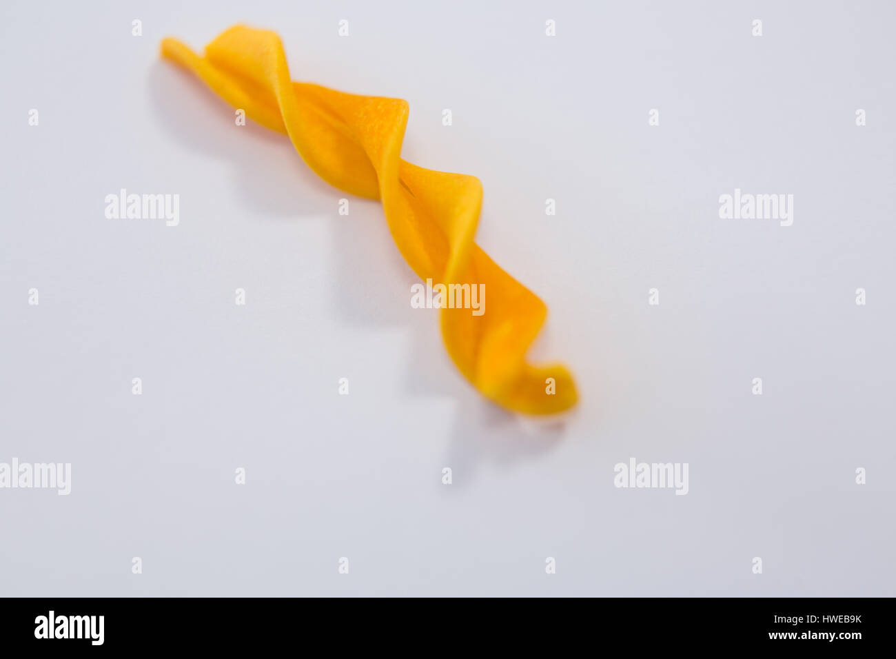 Yellow rotini isolated on white background Stock Photo - Alamy