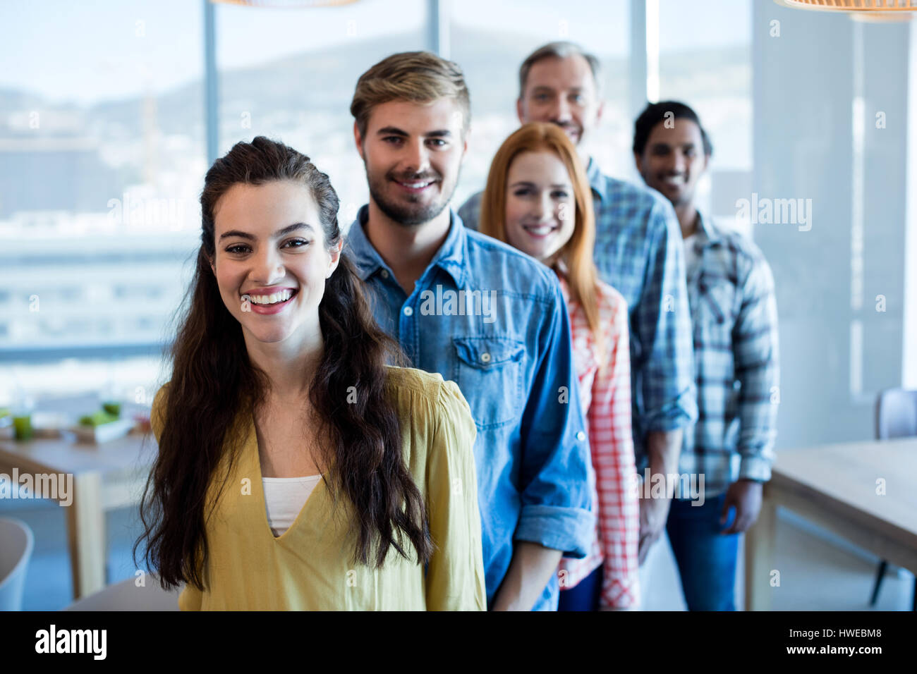 Happy creative business team standing in a line in office Stock Photo ...