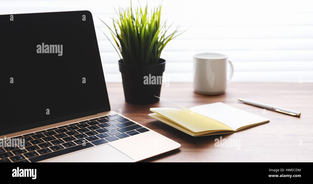 Laptop with notebook and coffee cup on office table Stock Photo - Alamy