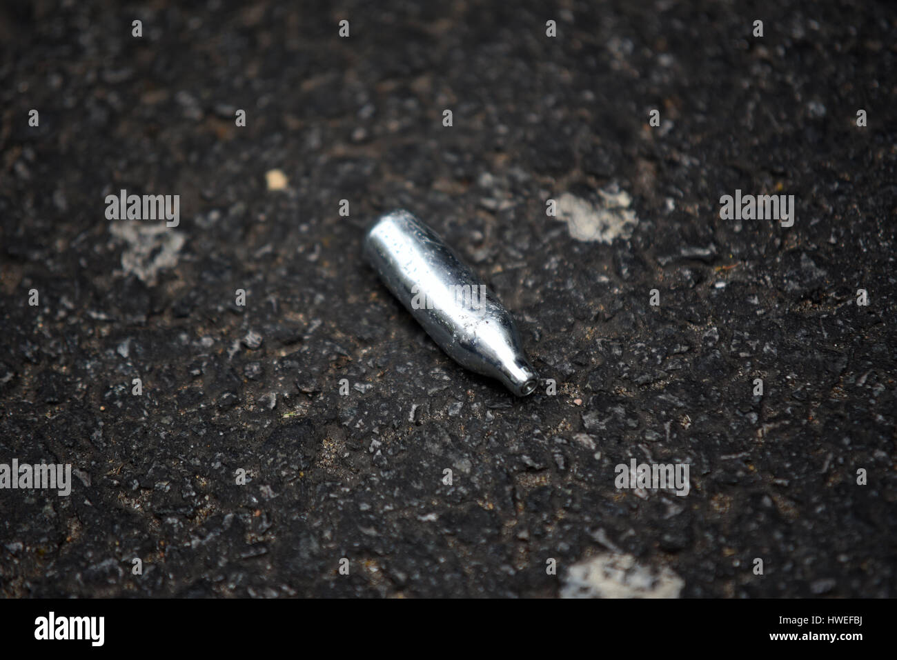 A discarded nitrous oxide (laughing gas) canister on the street in ...