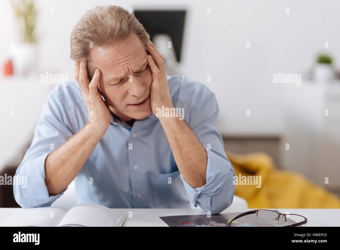 Portrait of tired man touching his head Stock Photo - Alamy