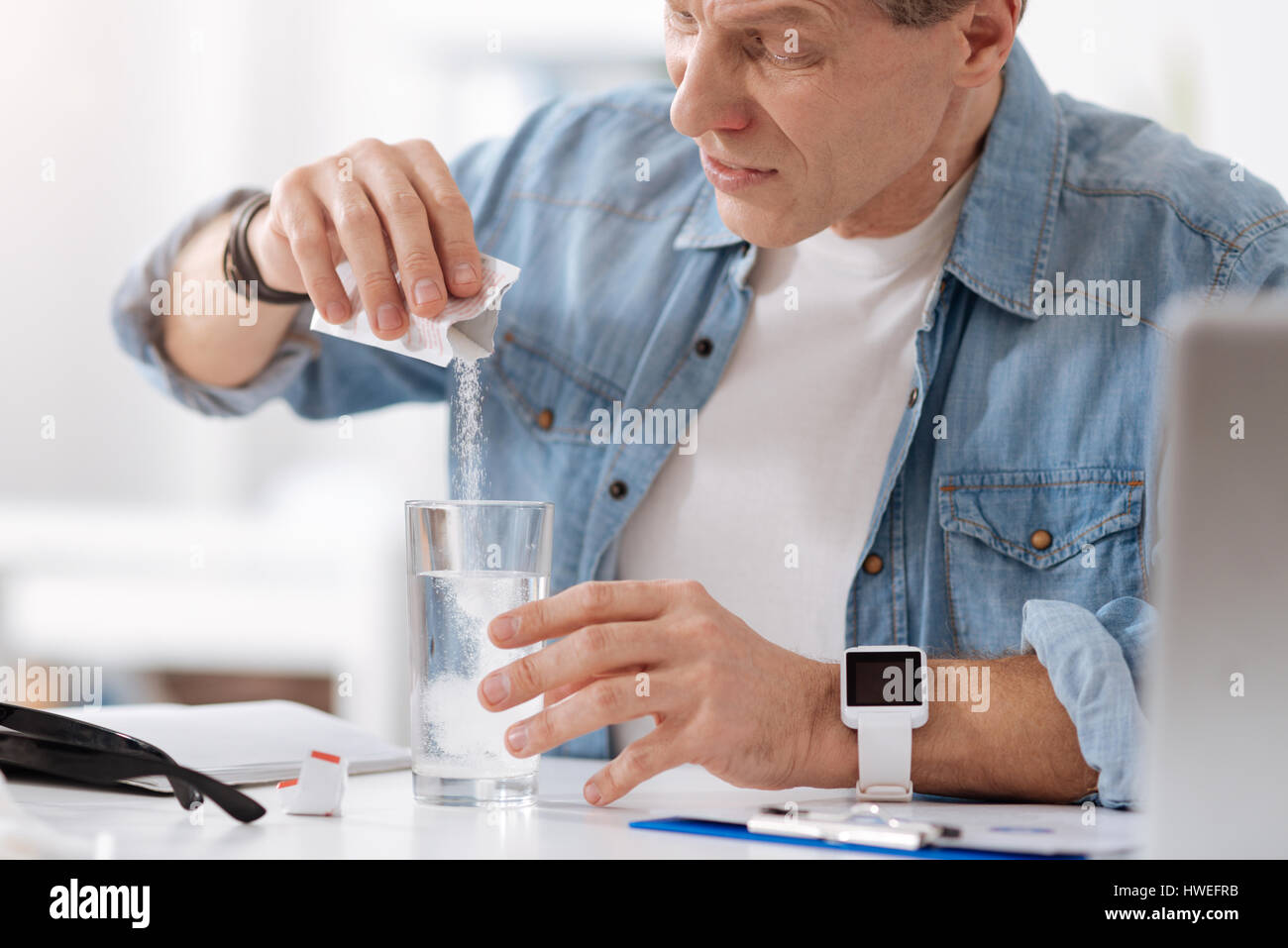 Serious male person adding powder to water Stock Photo - Alamy