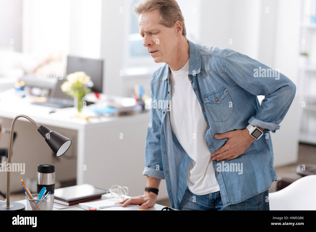 Disturbed male having pain in stomach Stock Photo - Alamy