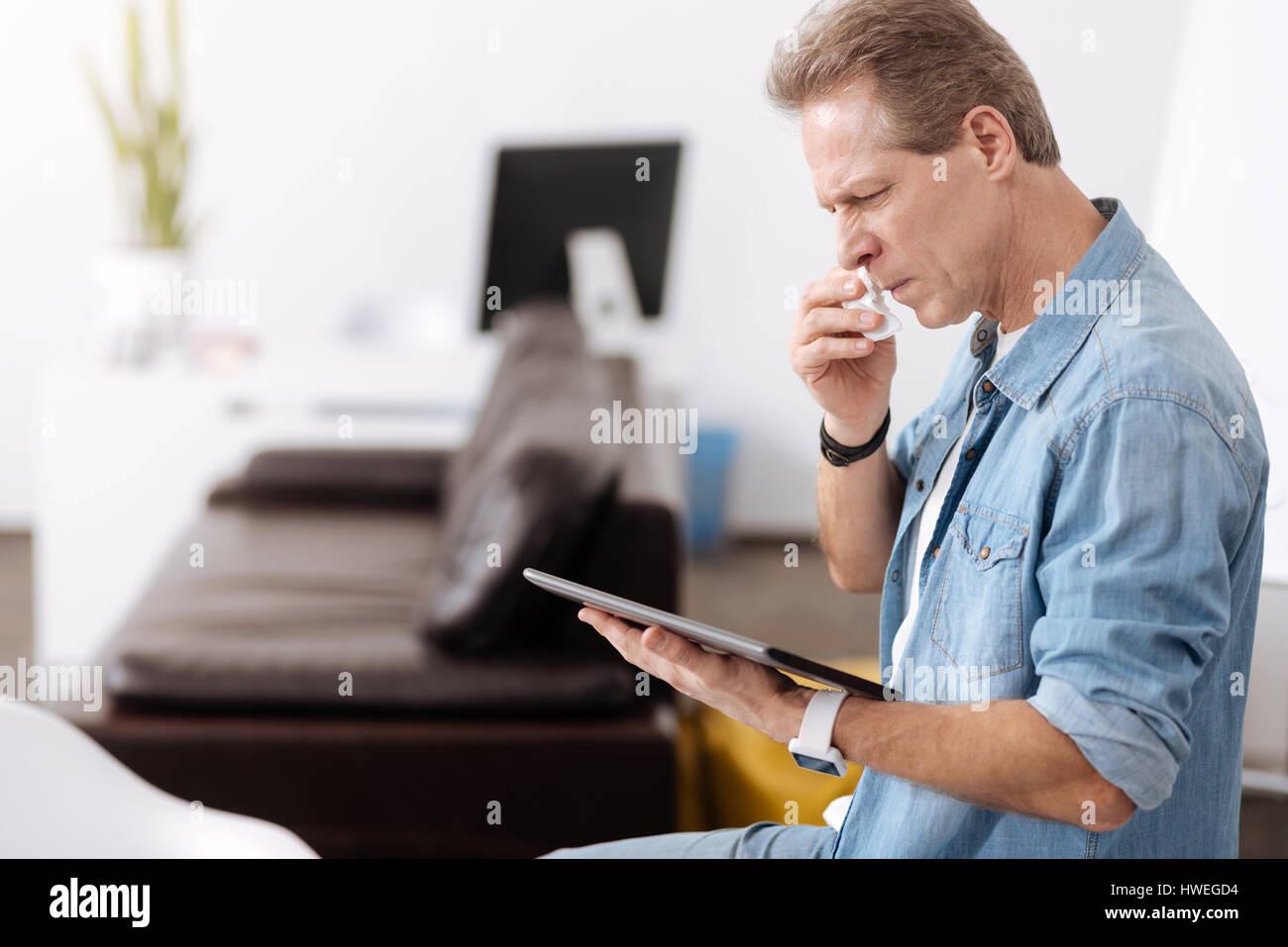 Attentive man working with tablet Stock Photo - Alamy