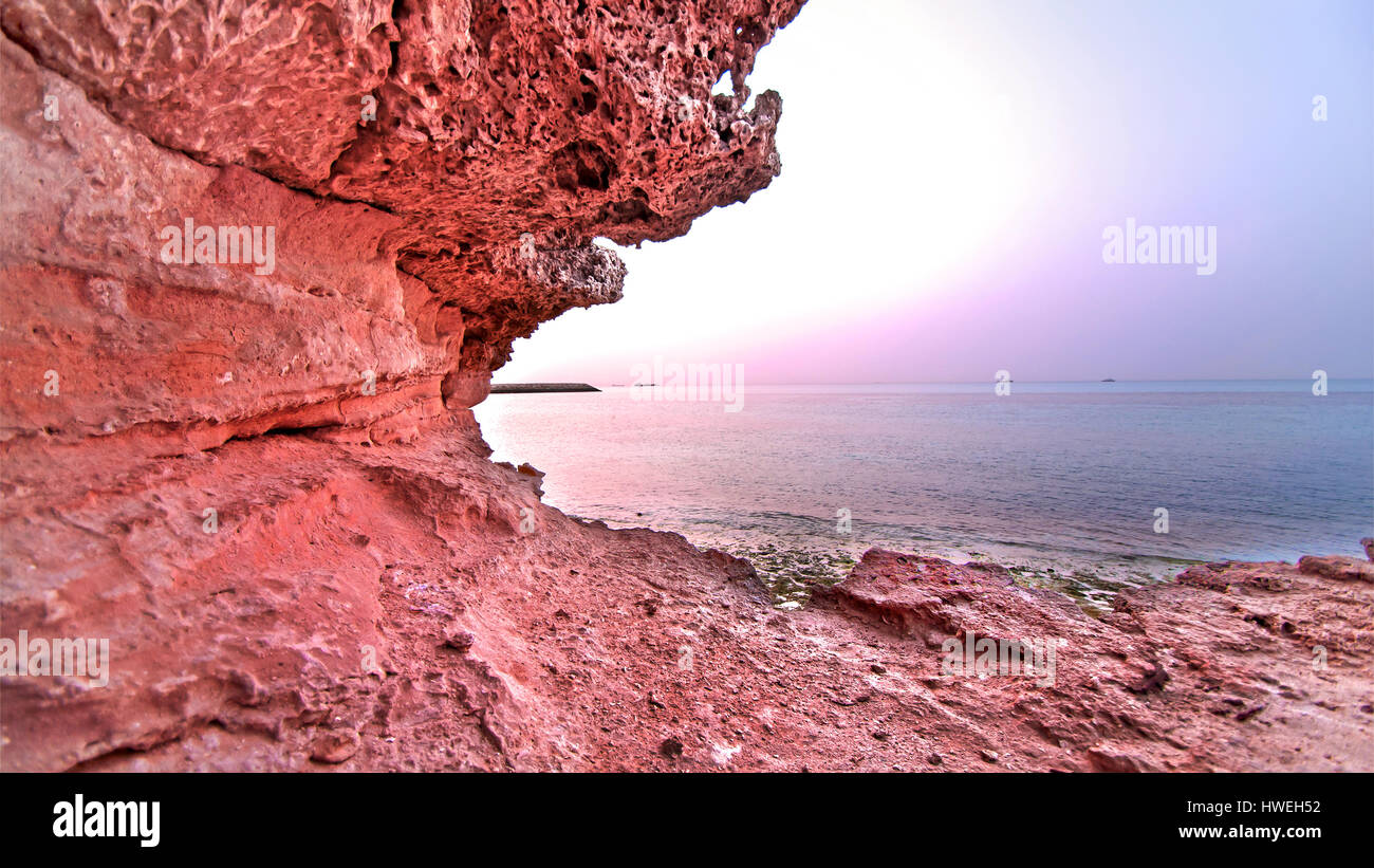 A red rocky cliff shore Stock Photo - Alamy