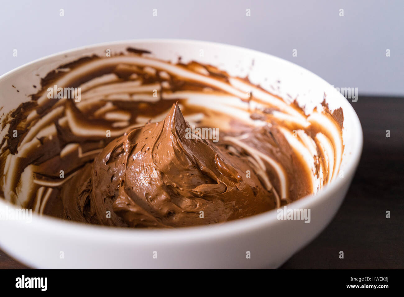 Top view of Paleo Chocolate Frosting in a white bowl, wooden table ...
