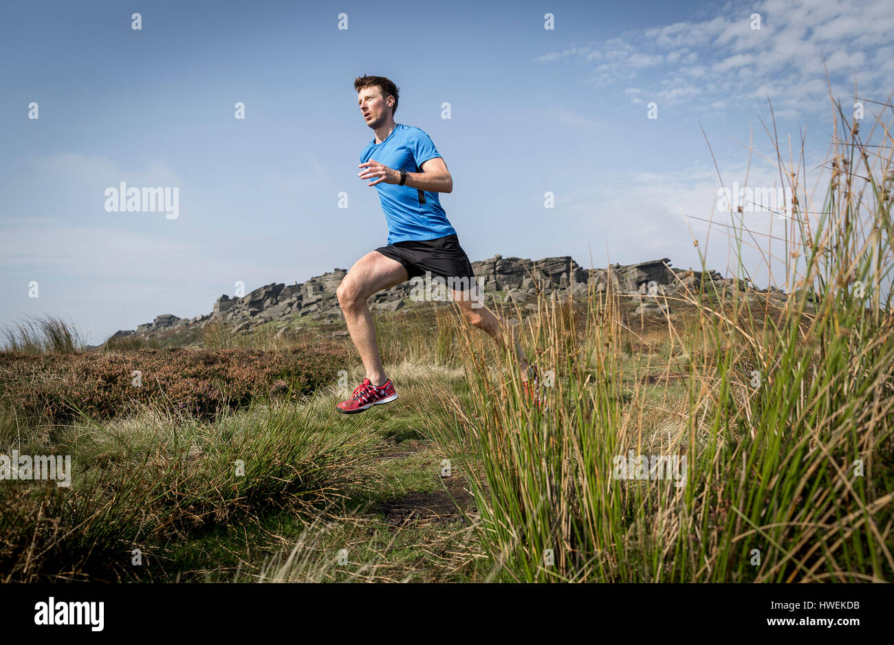 Male runner running down from Stanage Edge, Peak District, Derbyshire ...