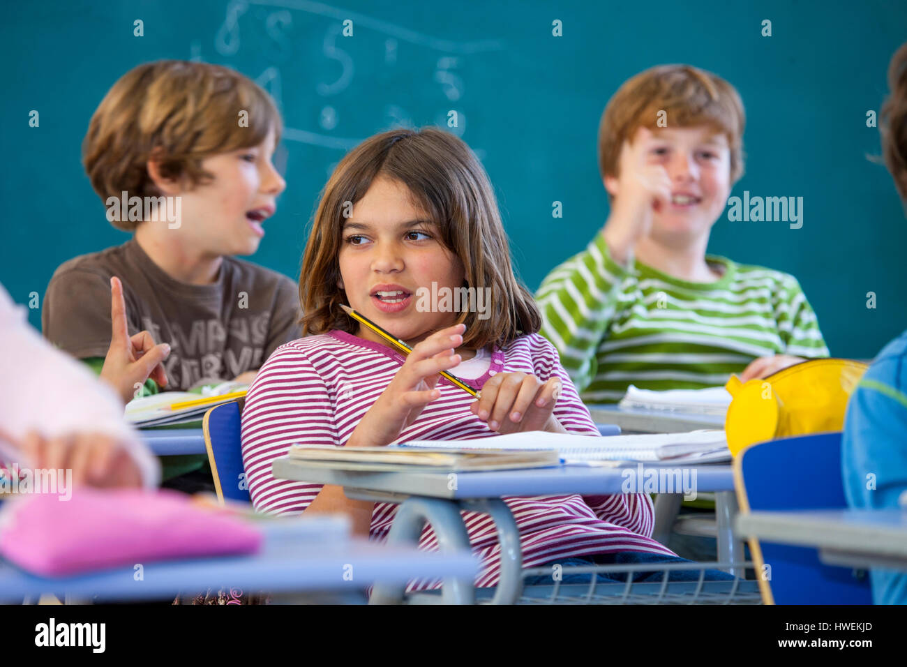 Primary schoolboys and girls chatting in classroom Stock Photo - Alamy