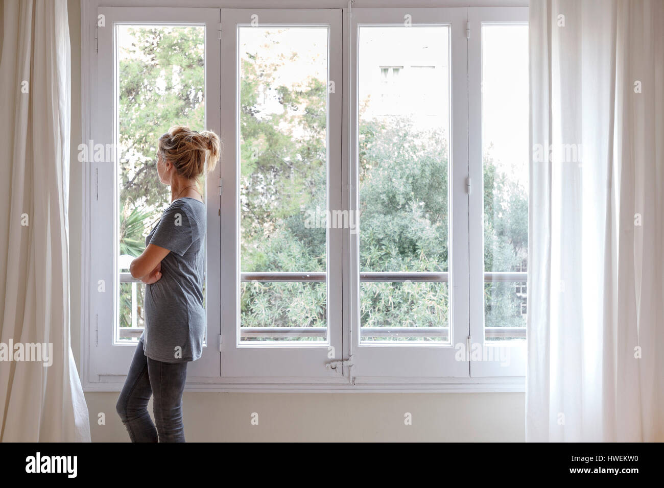 Woman looking out of window hi-res stock photography and images - Alamy