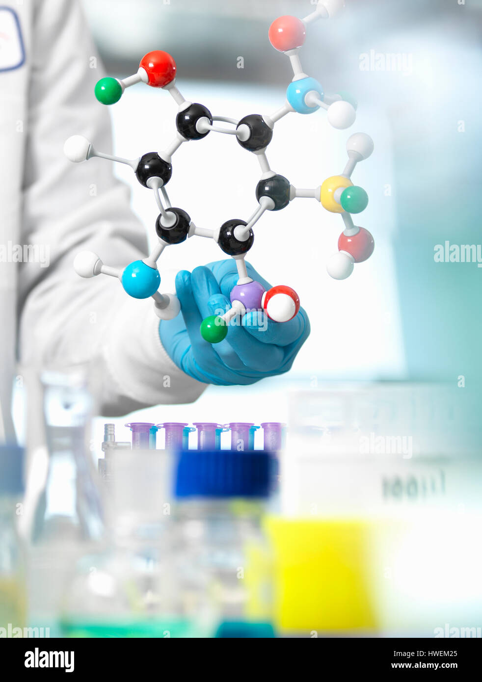 Researcher using a molecular model to understand a chemical formula in ...