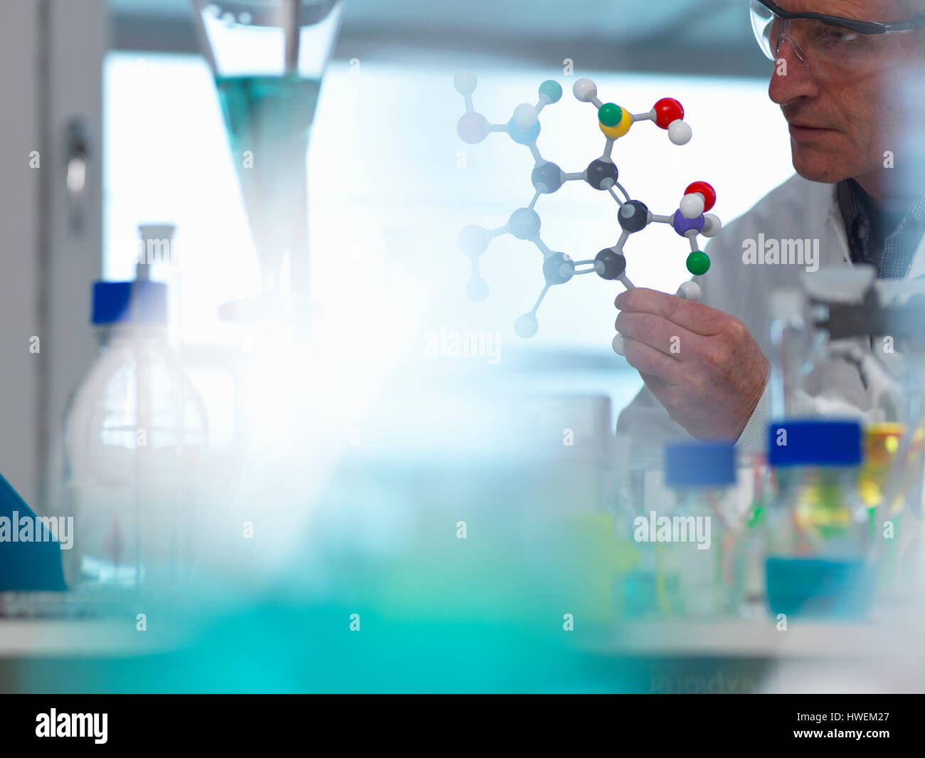 Researcher using a molecular model to understand a chemical formula in ...