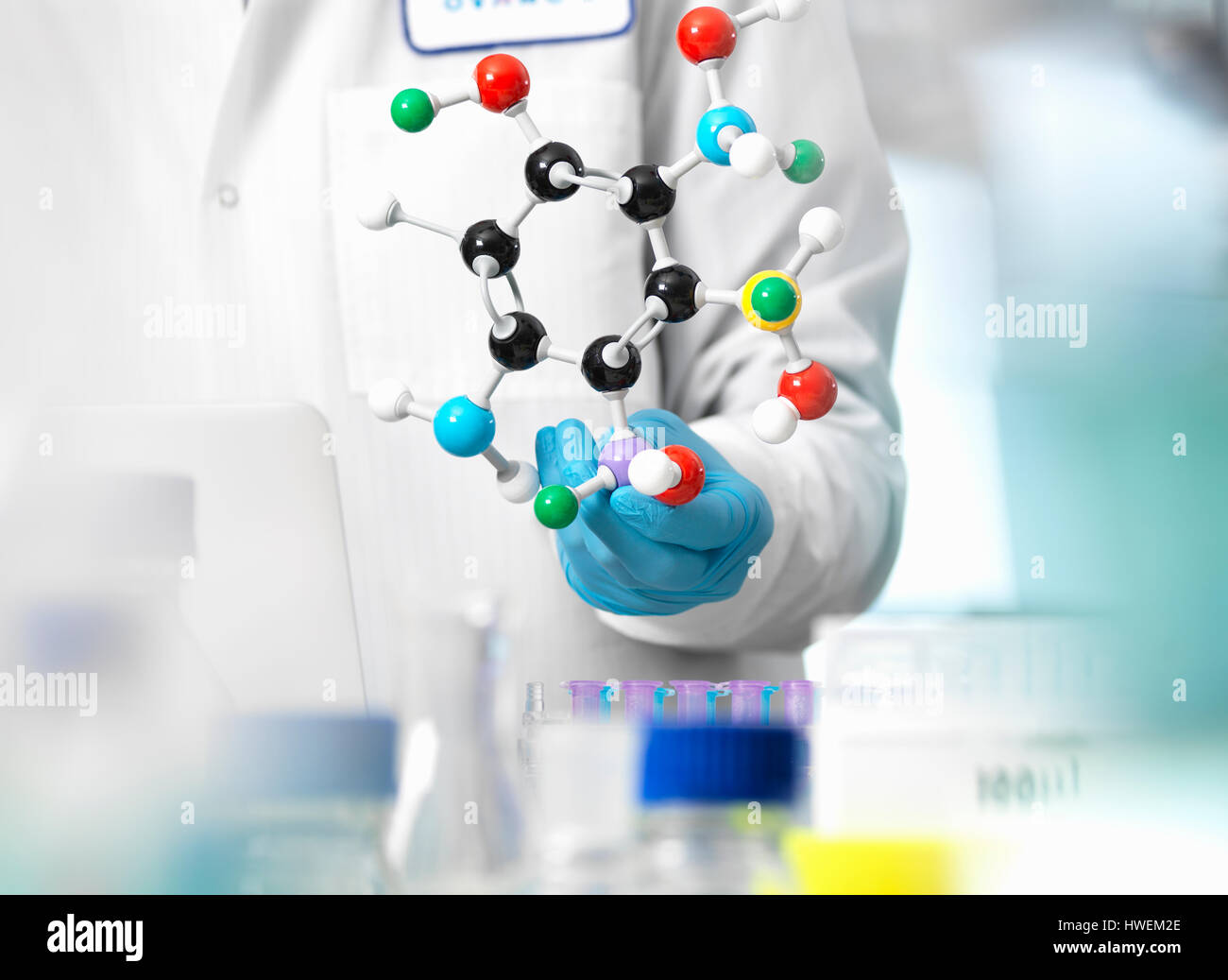 Researcher using a molecular model to understand a chemical formula in ...