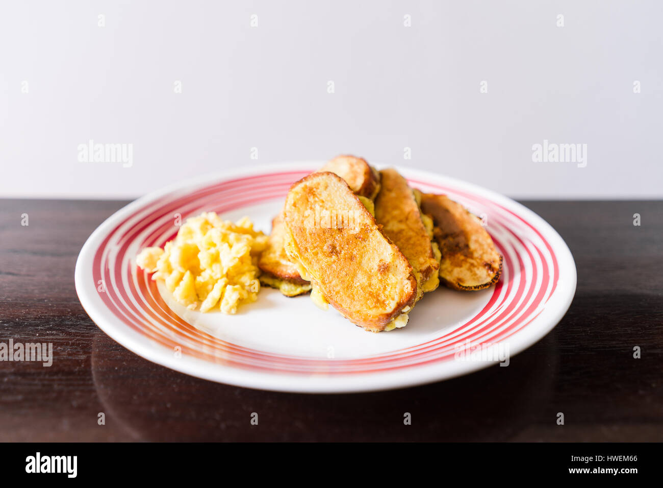 French Toast with Scrambled Eggs on a round plate. Wooden table Stock ...
