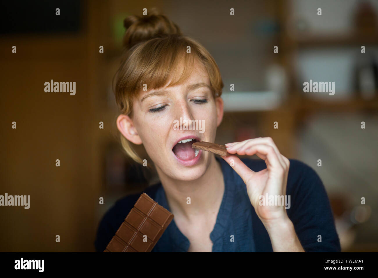 Young woman eating chocolate Stock Photo - Alamy