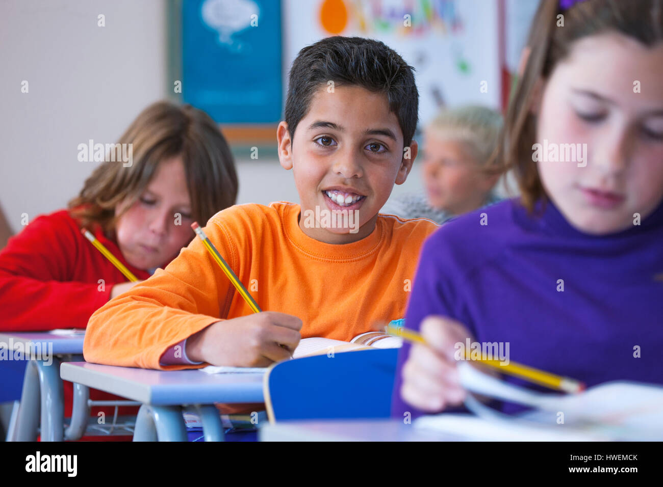 Portrait of boy in classroom, sitting at desk, doing classwork Stock ...