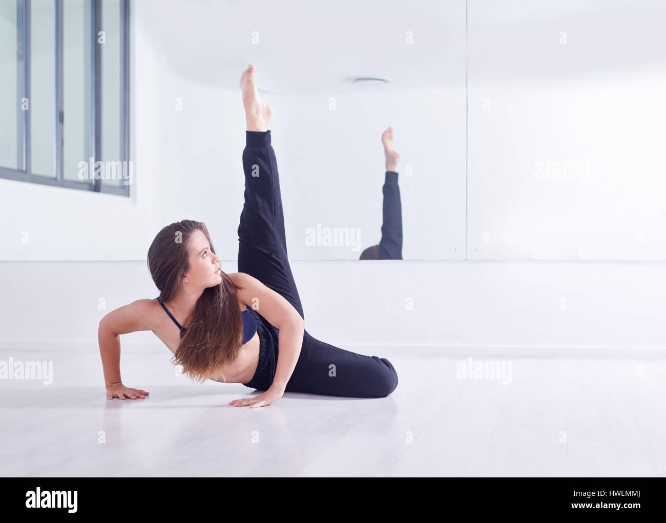 Young female ballet dancers practicing in dance studio, with leg raised ...