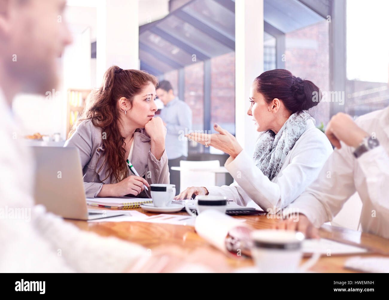 Over shoulder view of businesswomen explaining at office meeting Stock ...