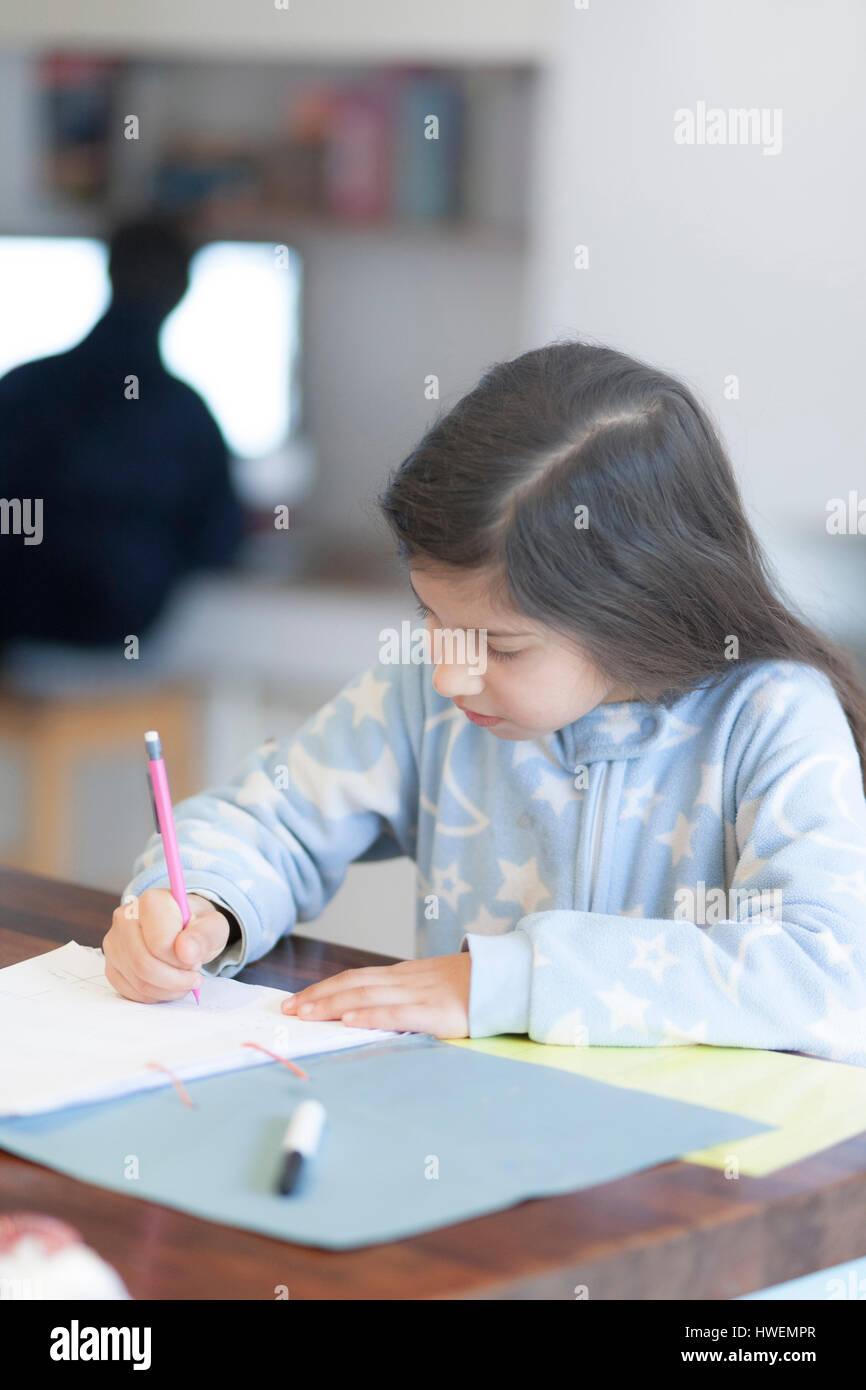 Girl doing homework at kitchen table Stock Photo - Alamy