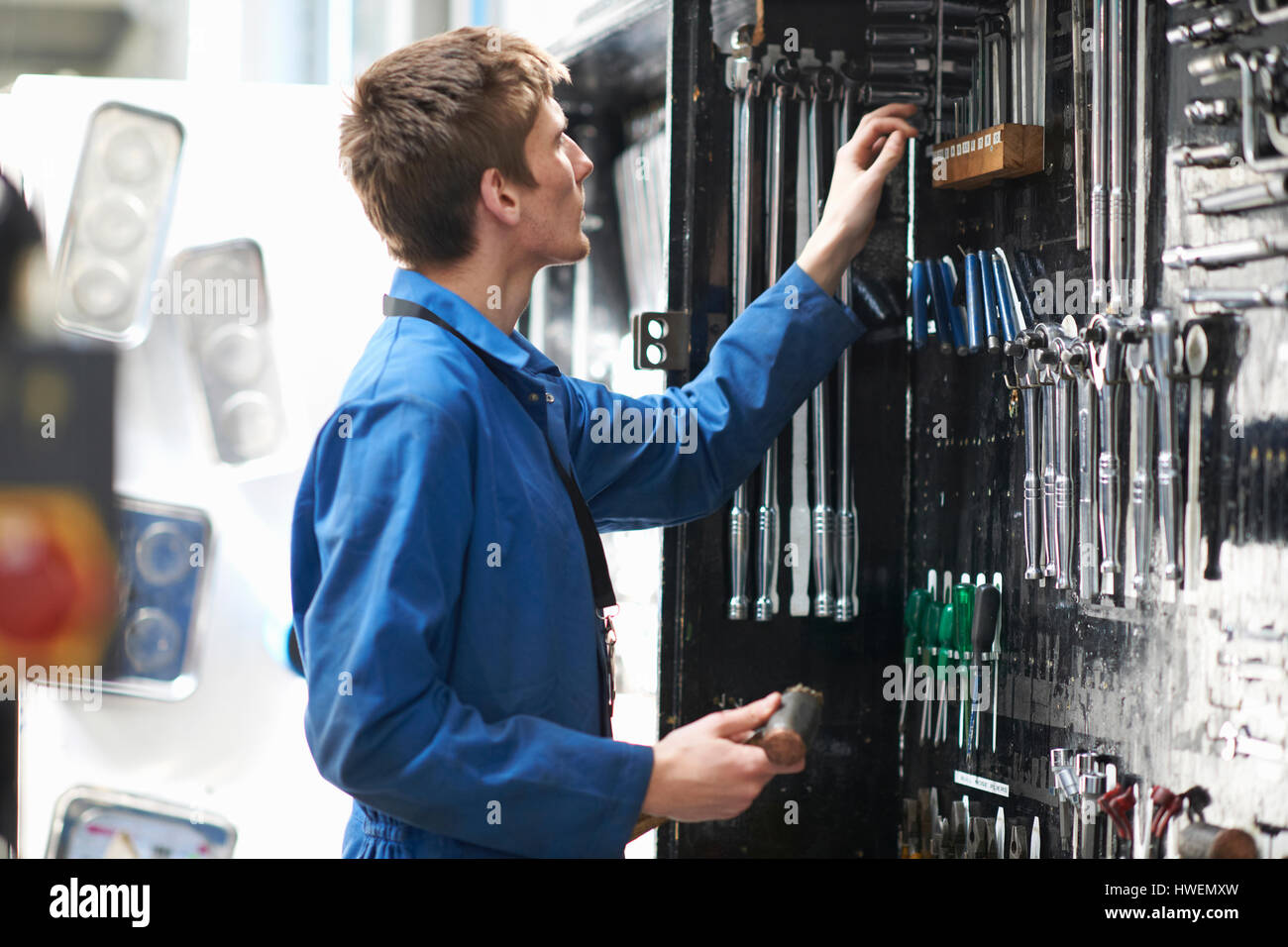 College mechanic student selecting tools from repair garage tool kit ...