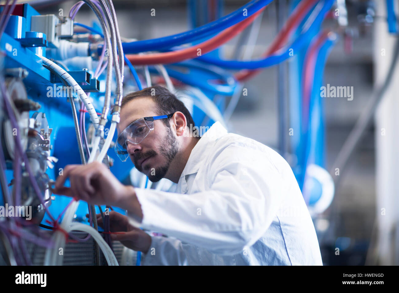 Scientist adjusting heavy machinery Stock Photo - Alamy
