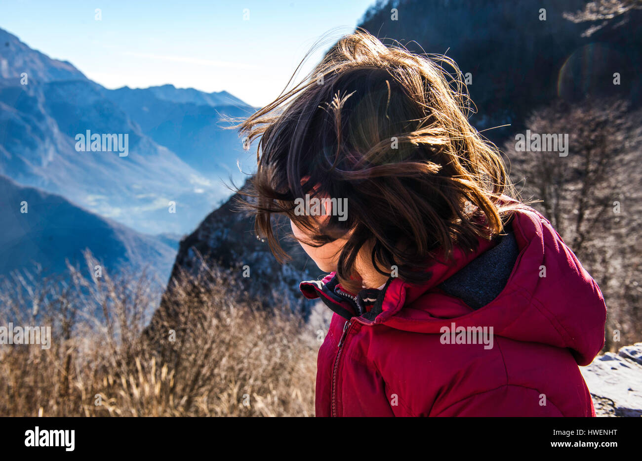 Over shoulder view of boy looking out at mountain landscape, Italy ...