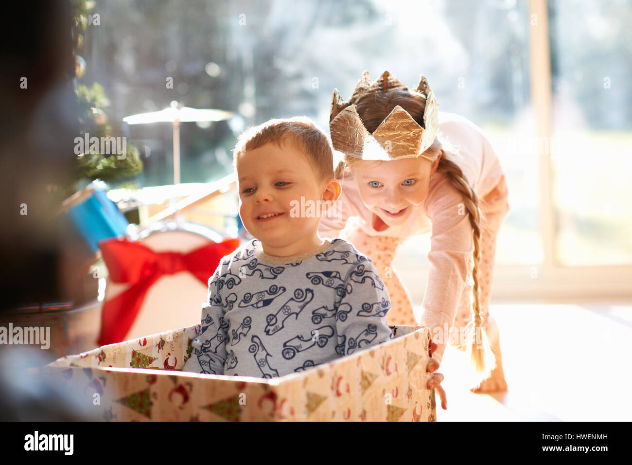 Girl pushing brother in cardboard box at christmas Stock Photo - Alamy