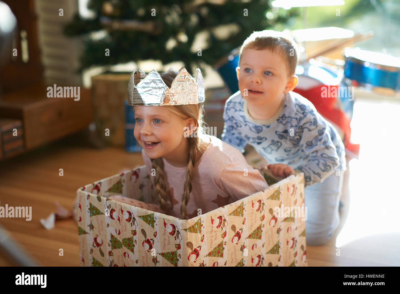 Boy pushing sister in cardboard box at christmas Stock Photo - Alamy