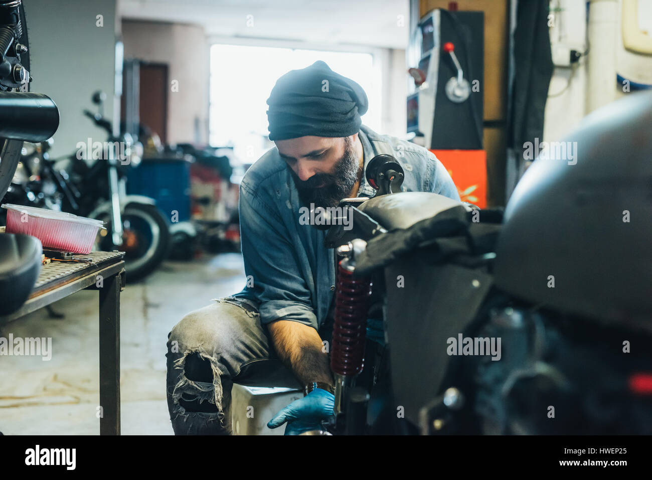 Mature man, working on motorcycle in garage Stock Photo - Alamy