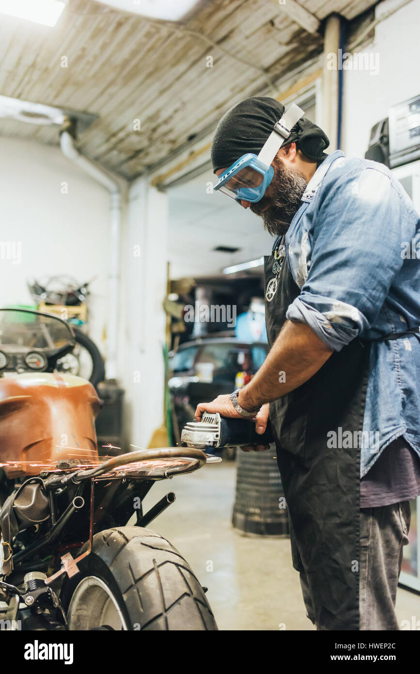 Mature man, working on motorcycle in garage Stock Photo - Alamy