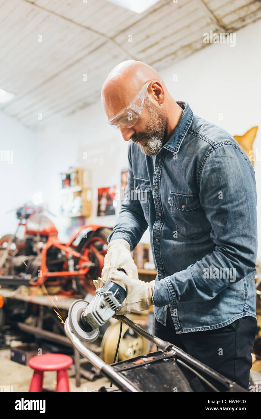 Mature man, working on motorcycle in garage Stock Photo - Alamy