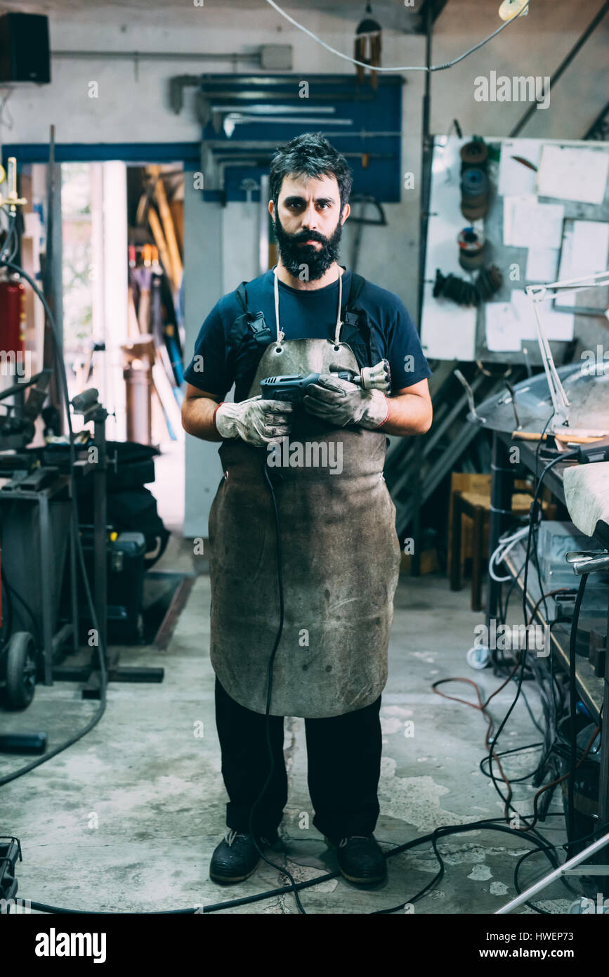 Portrait of male metalworker in apron, forge workshop Stock Photo - Alamy