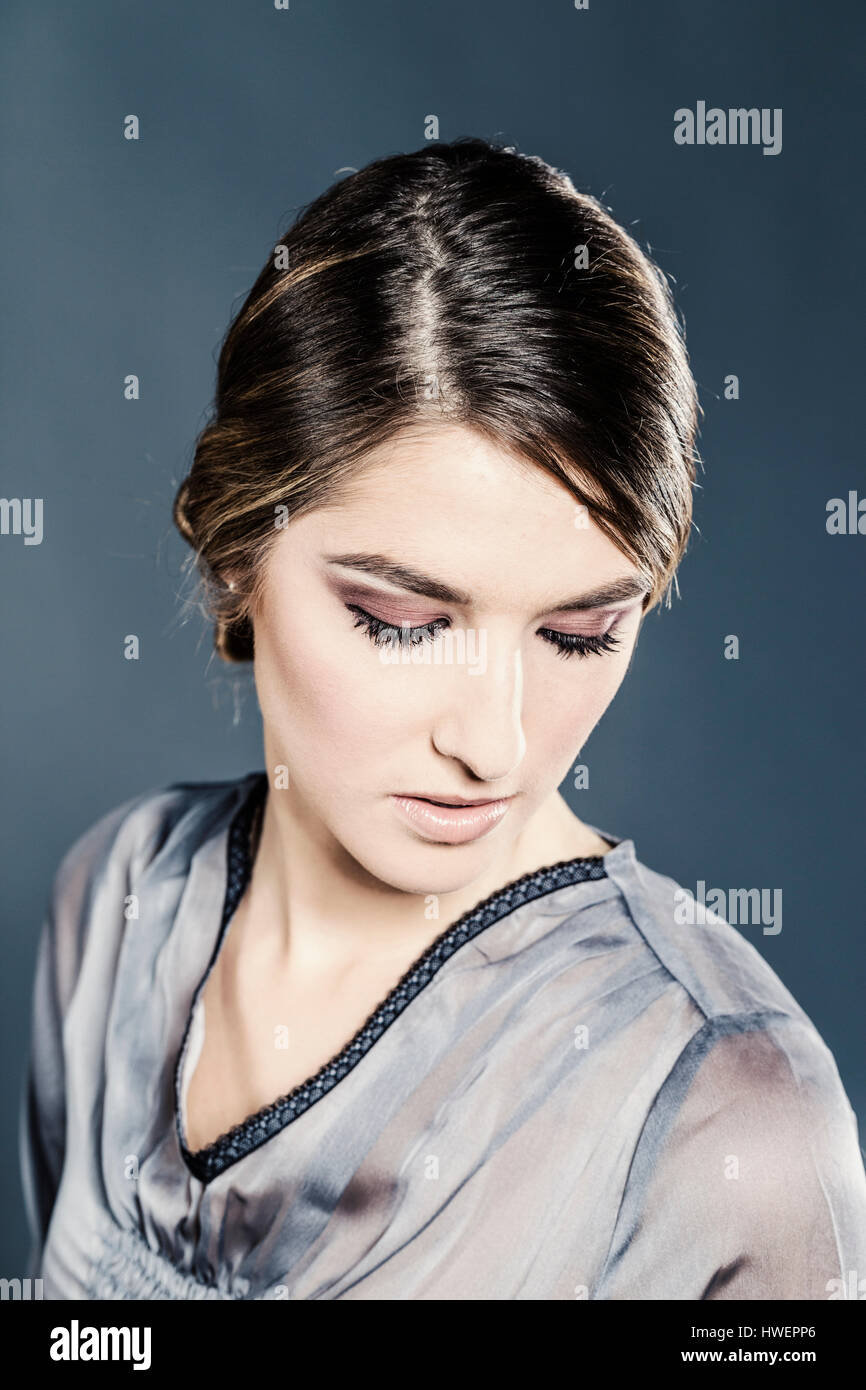 Studio portrait of beautiful young woman looking down Stock Photo - Alamy