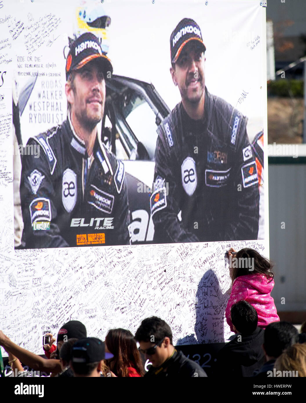 Fans sign a billboard near a make shift memorial for actor Paul Walker ...