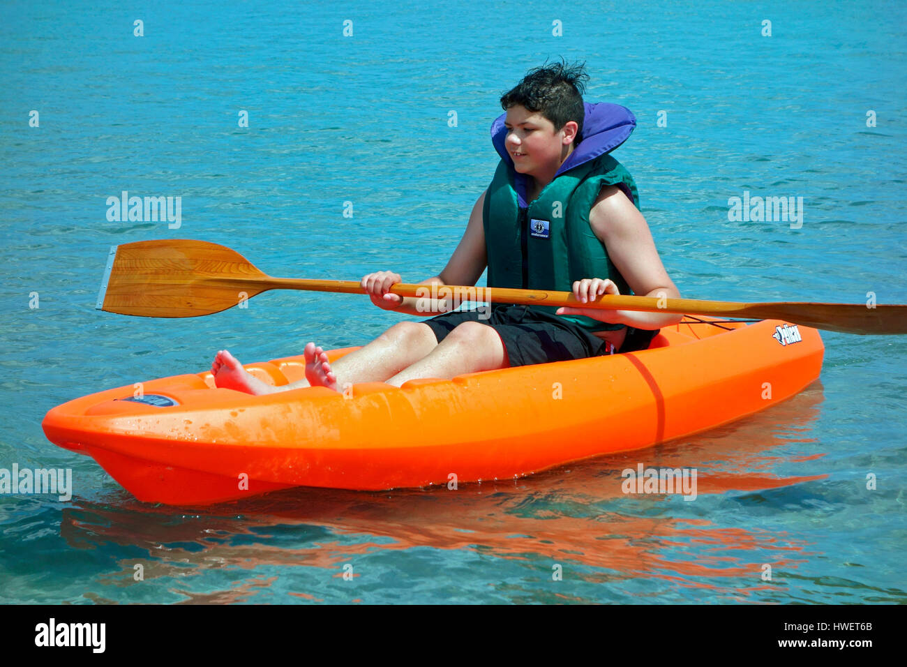 A young boy paddling a kayak Stock Photo - Alamy