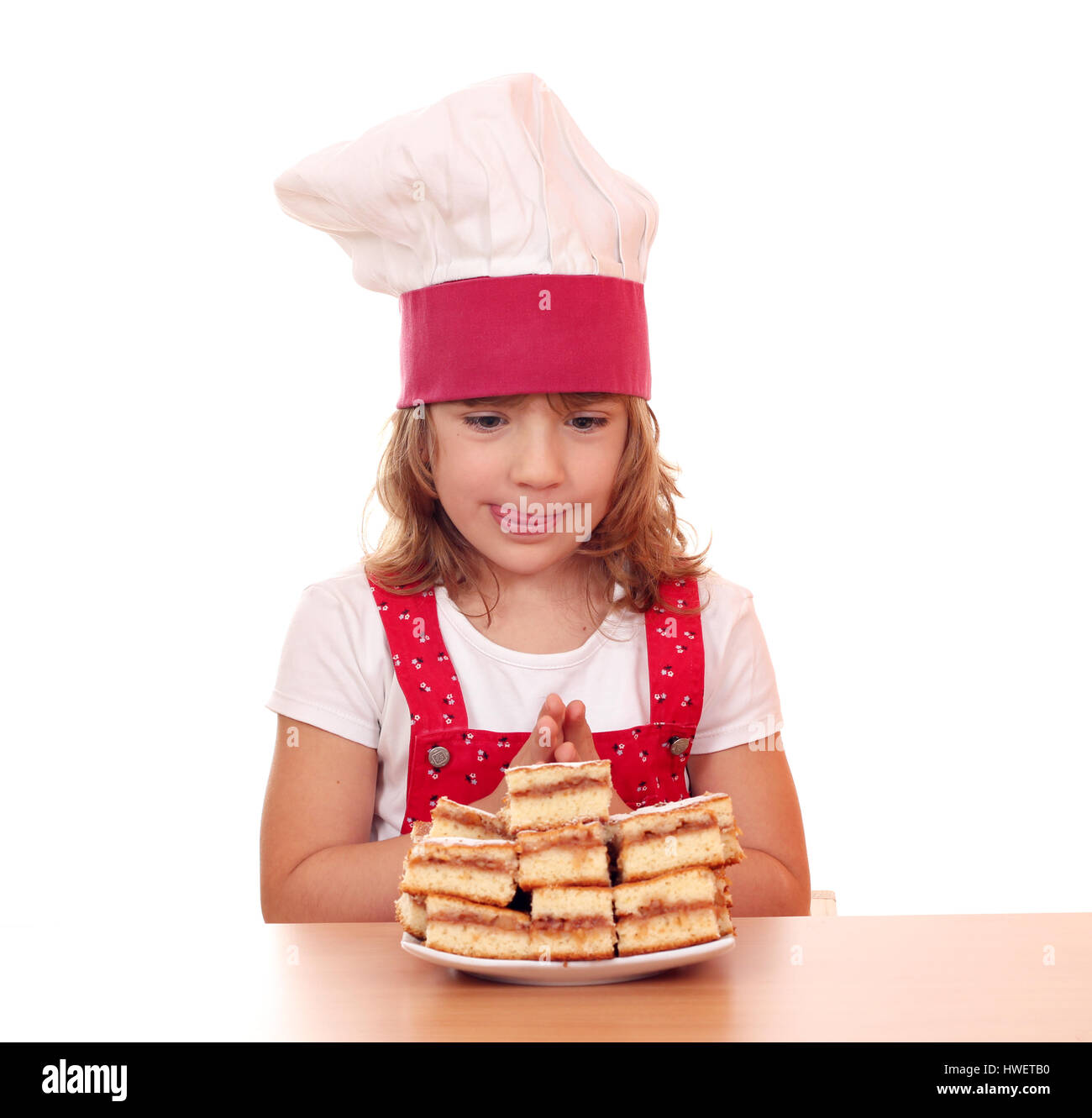hungry little girl cook looking at apple cakes Stock Photo - Alamy