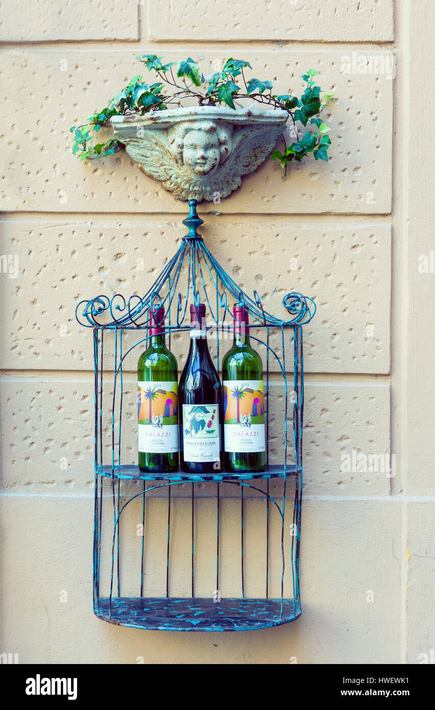 Wine shop exterior detail with decorative holder and three empty wine ...