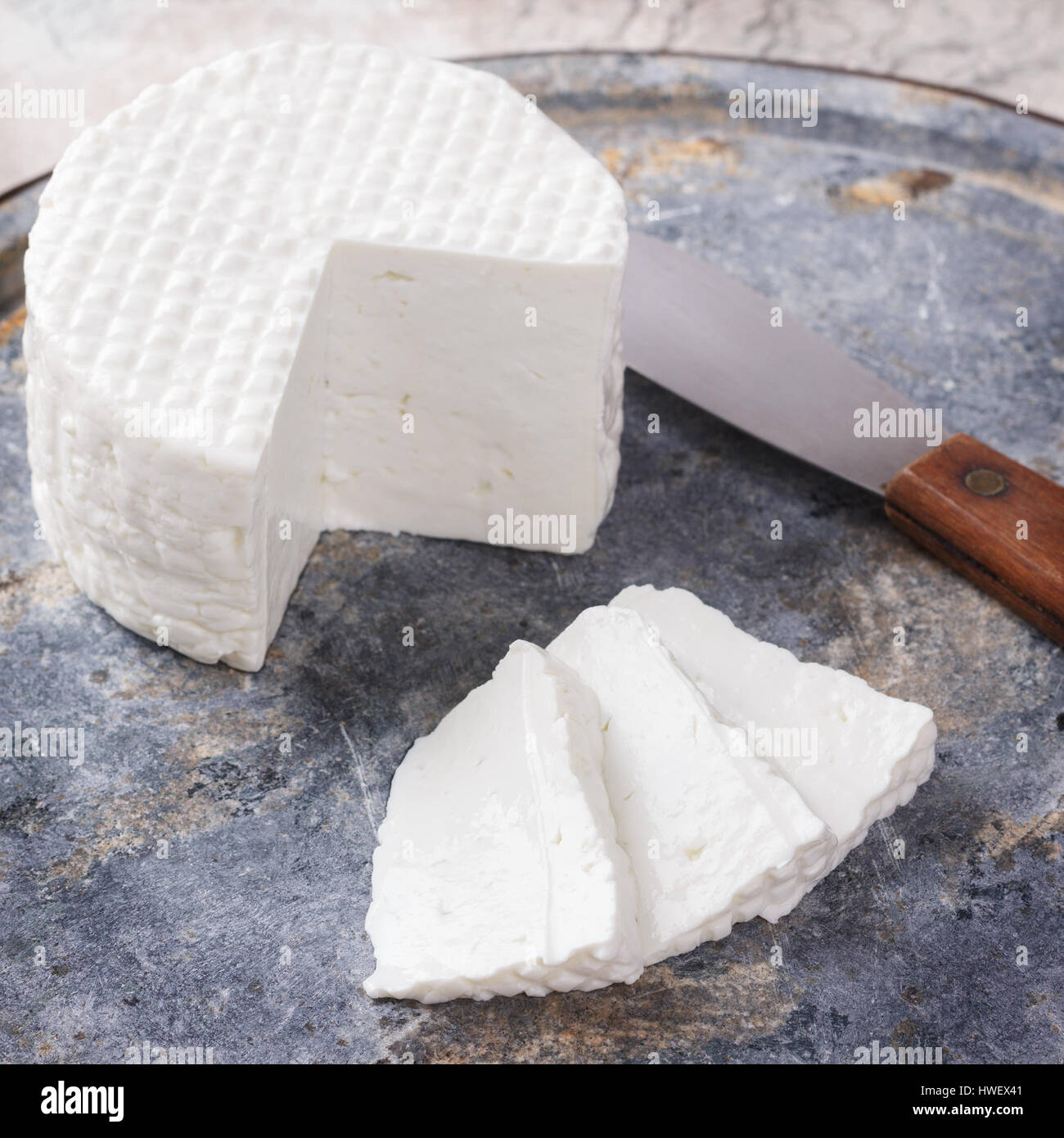 Wheel of brazilian traditional cheese Minas on gray board. Selective ...