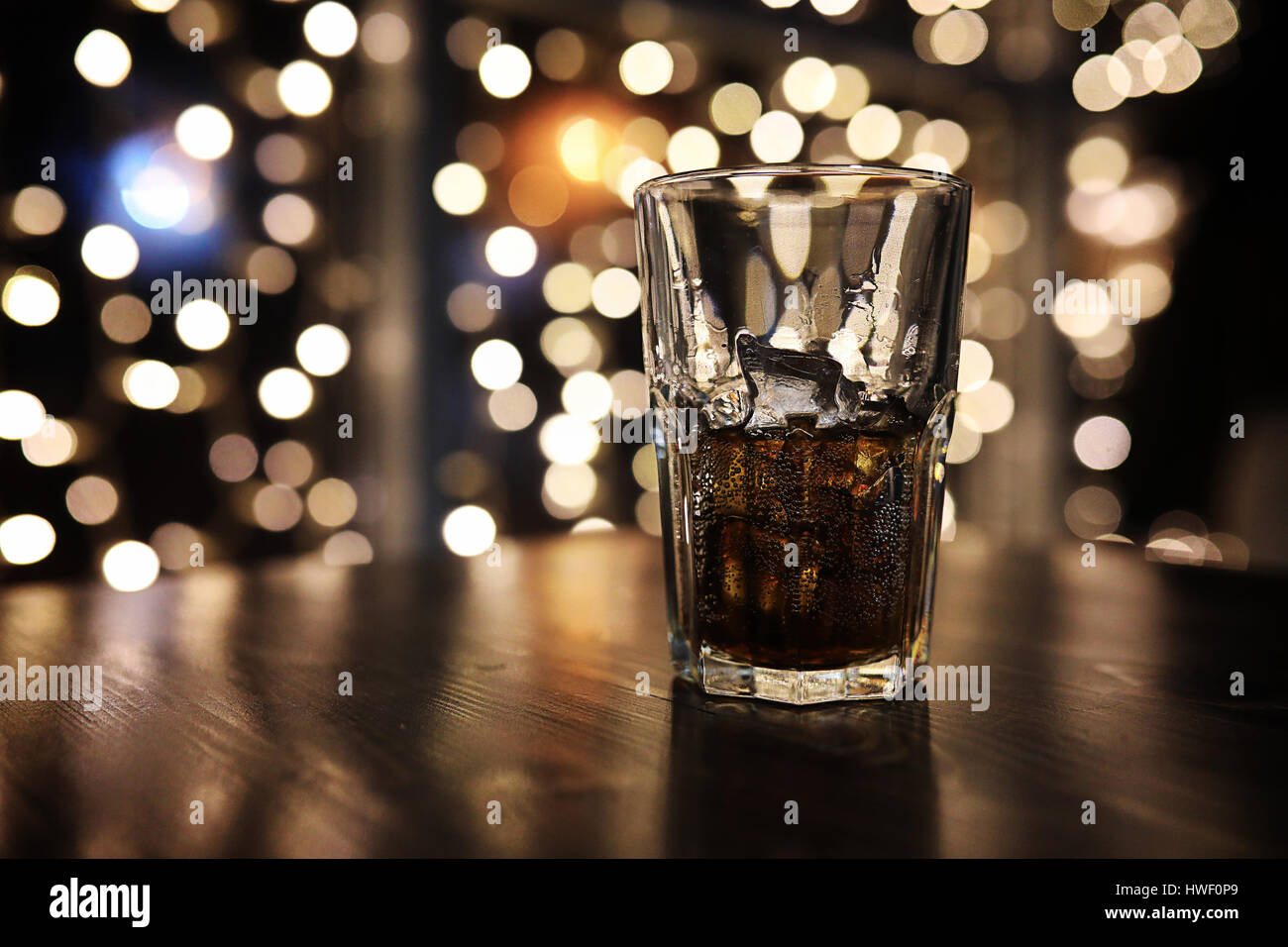 glass of alcohol with ice on blured background with circle bokeh Stock ...